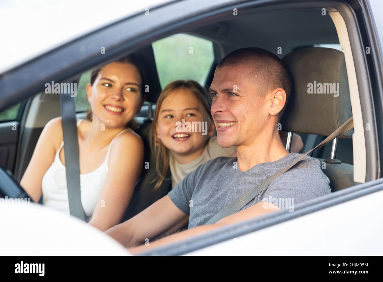 Positive family of three driving in the car Stock Photo - Alamy