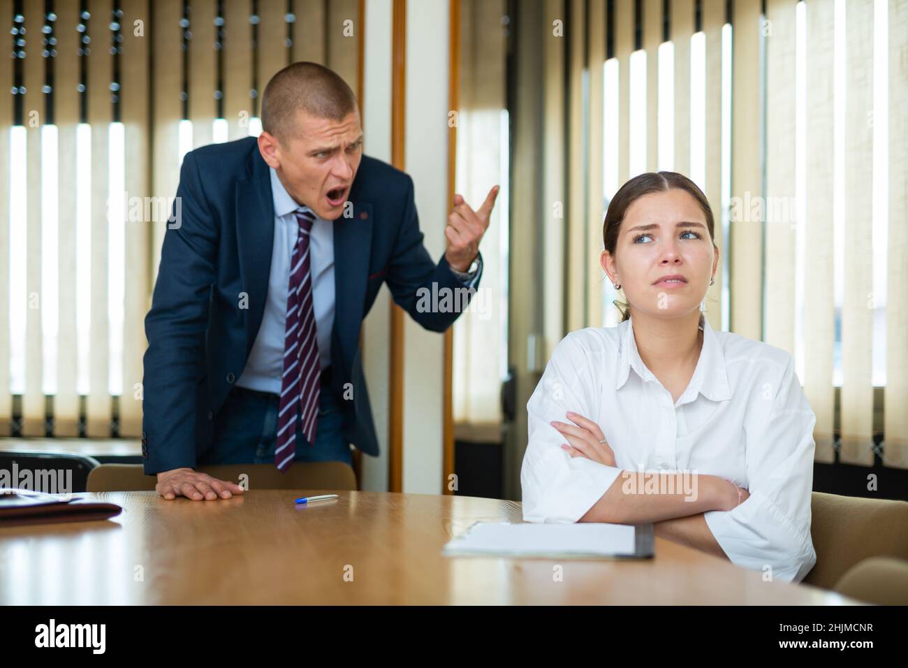 Emotional young boss berates his secretary girl in the conference room ...