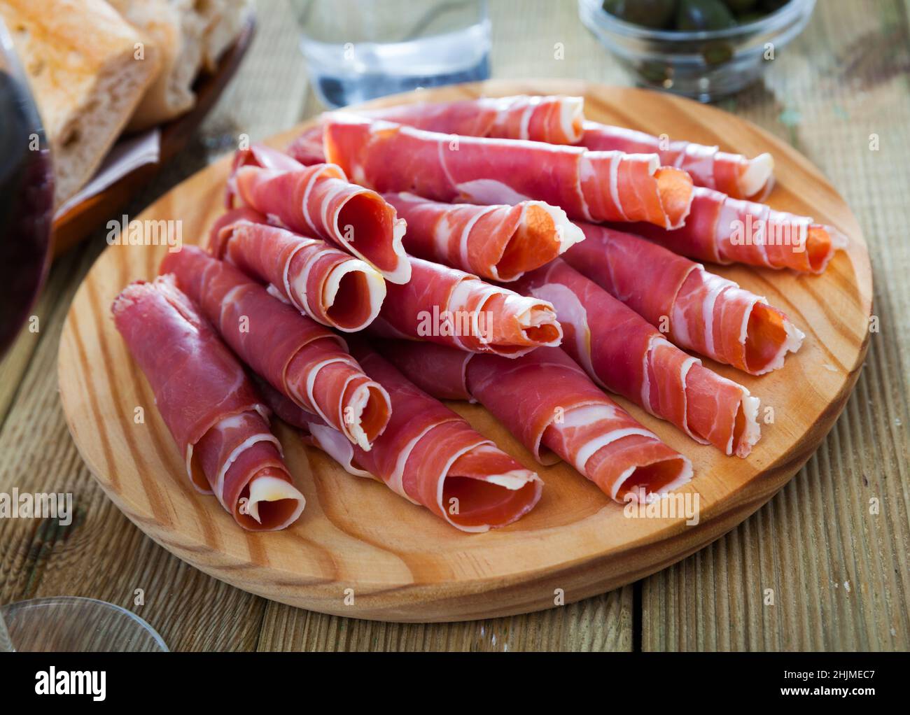 Rolled up slices of dry-cured ham Stock Photo - Alamy