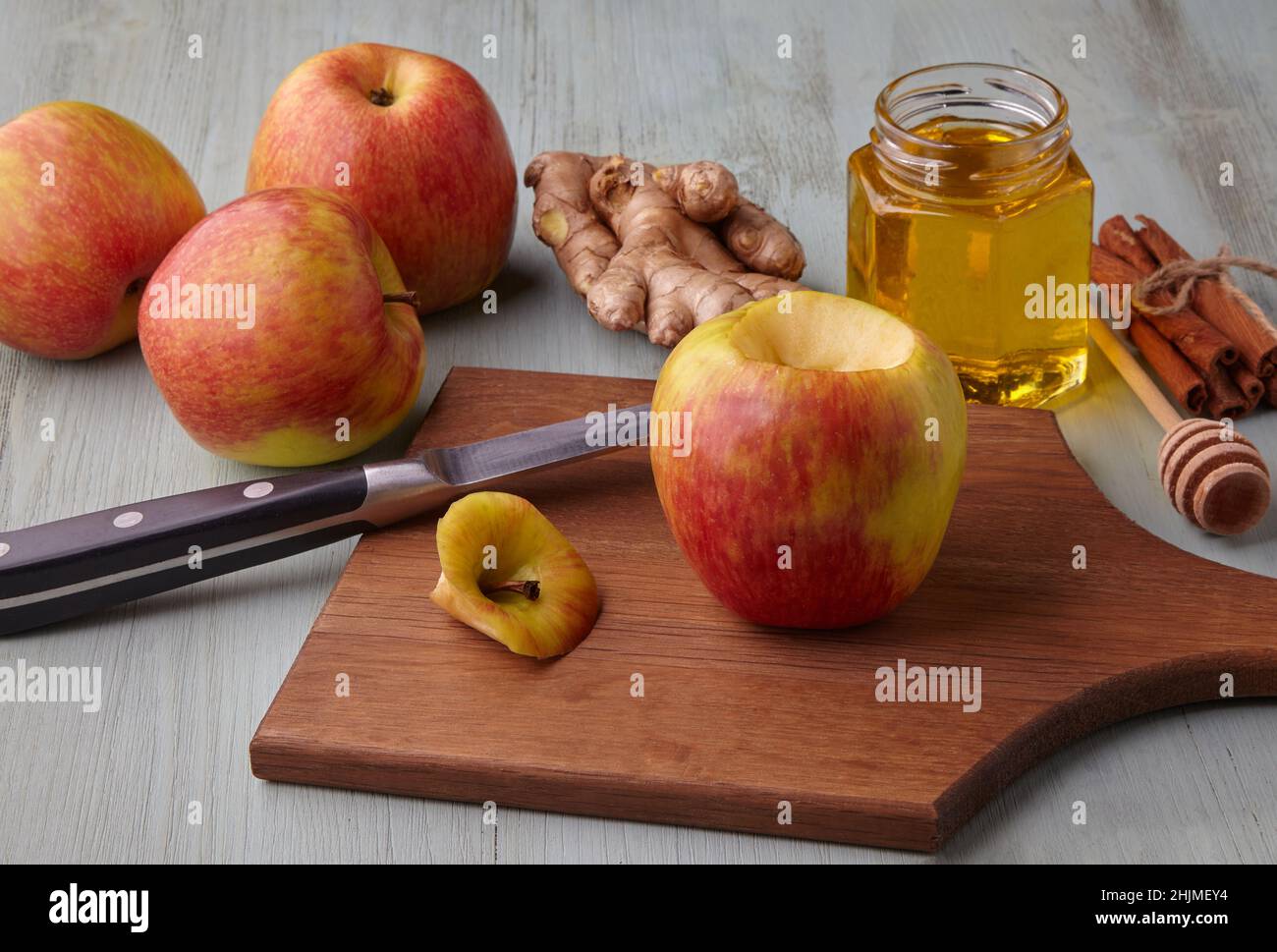 Apple prepared for baking in the oven surrounded by ingredients with ...