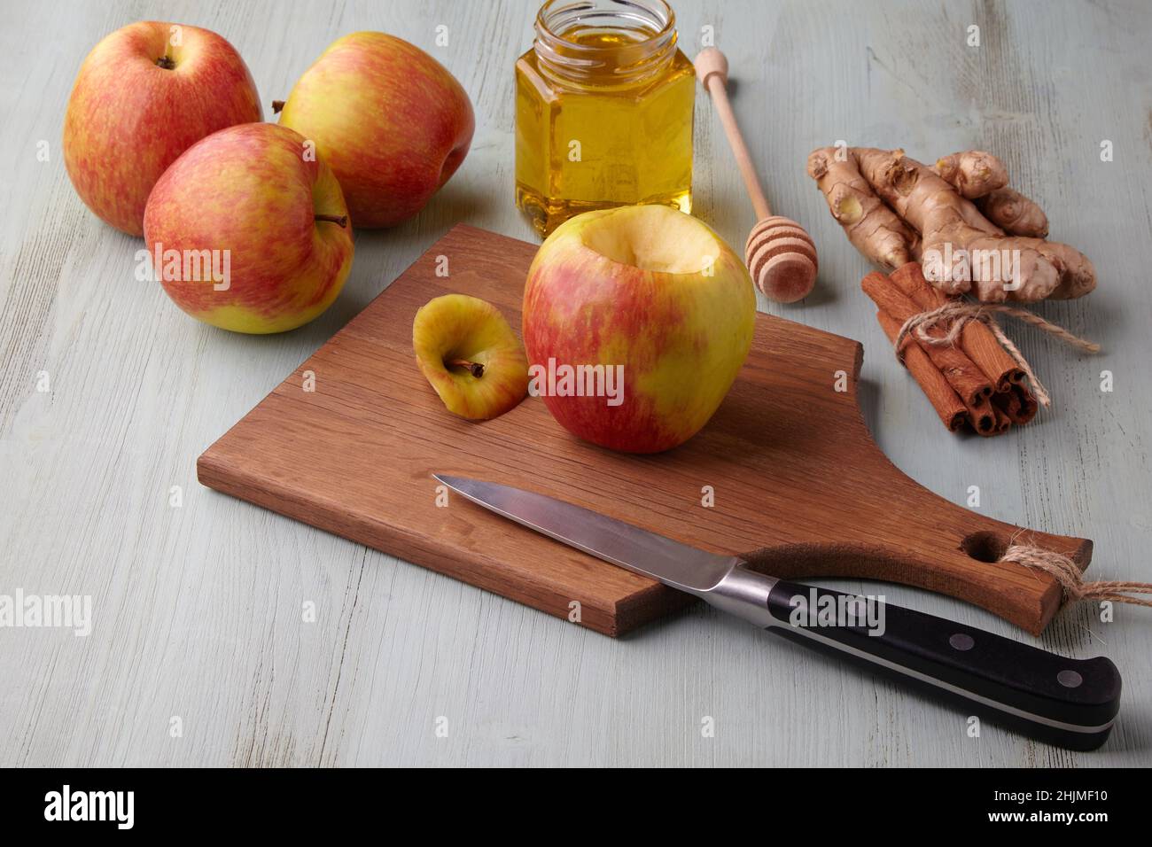 Apple prepared for baking in the oven surrounded by ingredients with ...