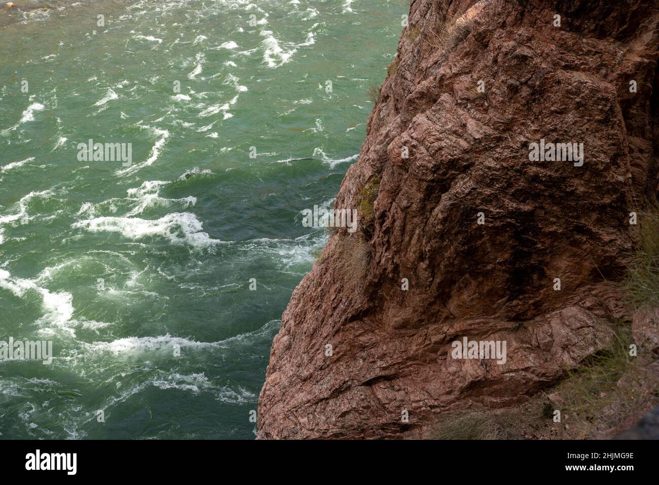 Colorado River Flowing Past A Tall Red Cliff through the Grand Canyon ...