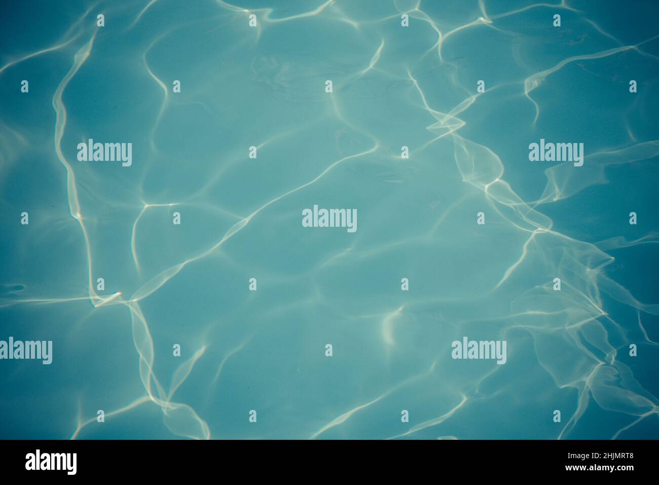 Blue pool water with sun reflections background Stock Photo - Alamy
