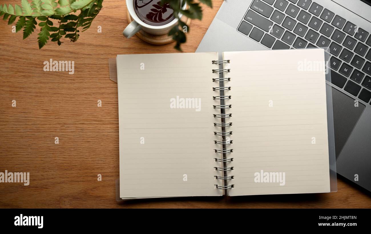 Simple workspace or study table with empty spiral notebook page on ...