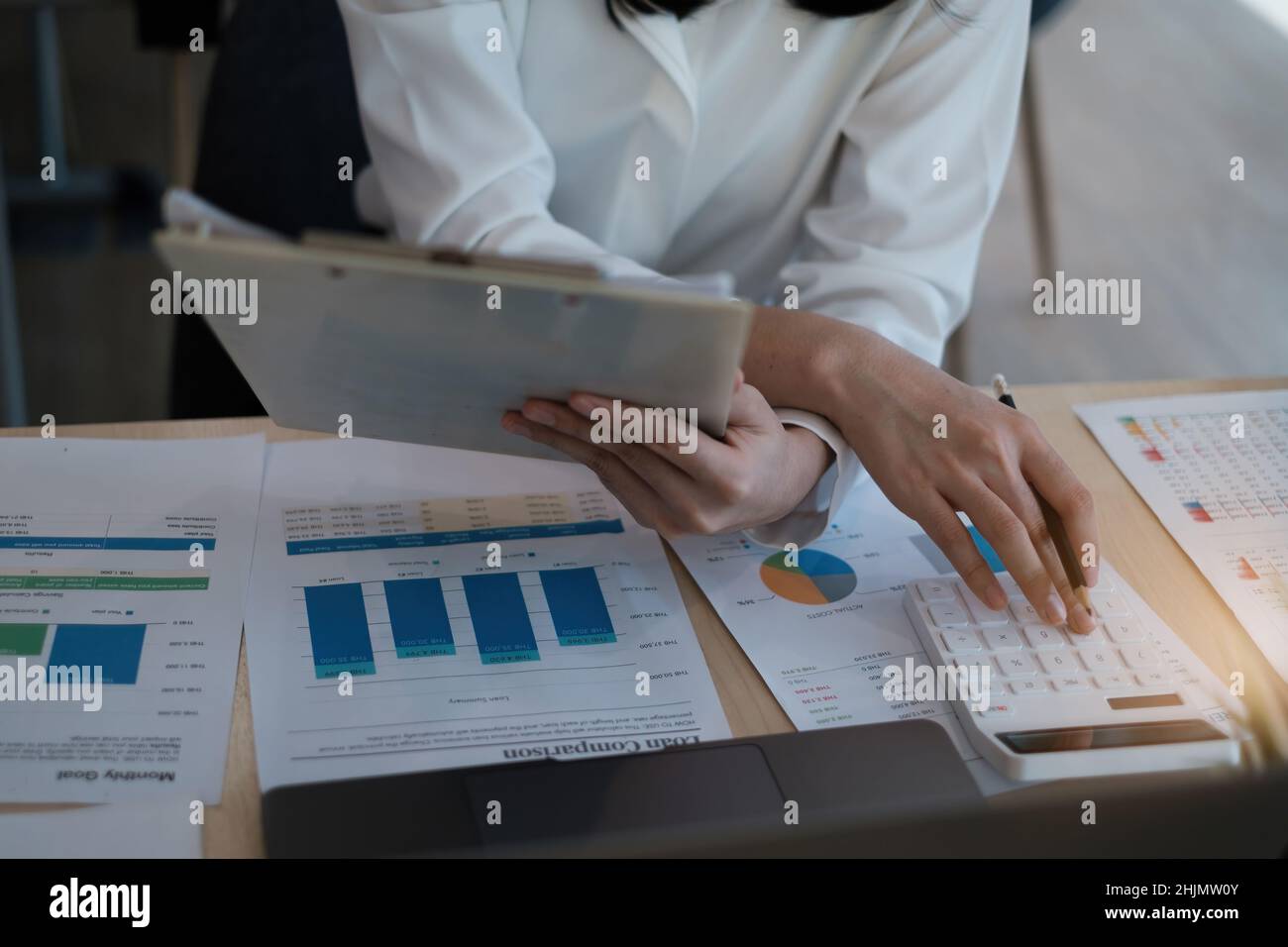 A business woman accountant or banker does an audit and calculates ...