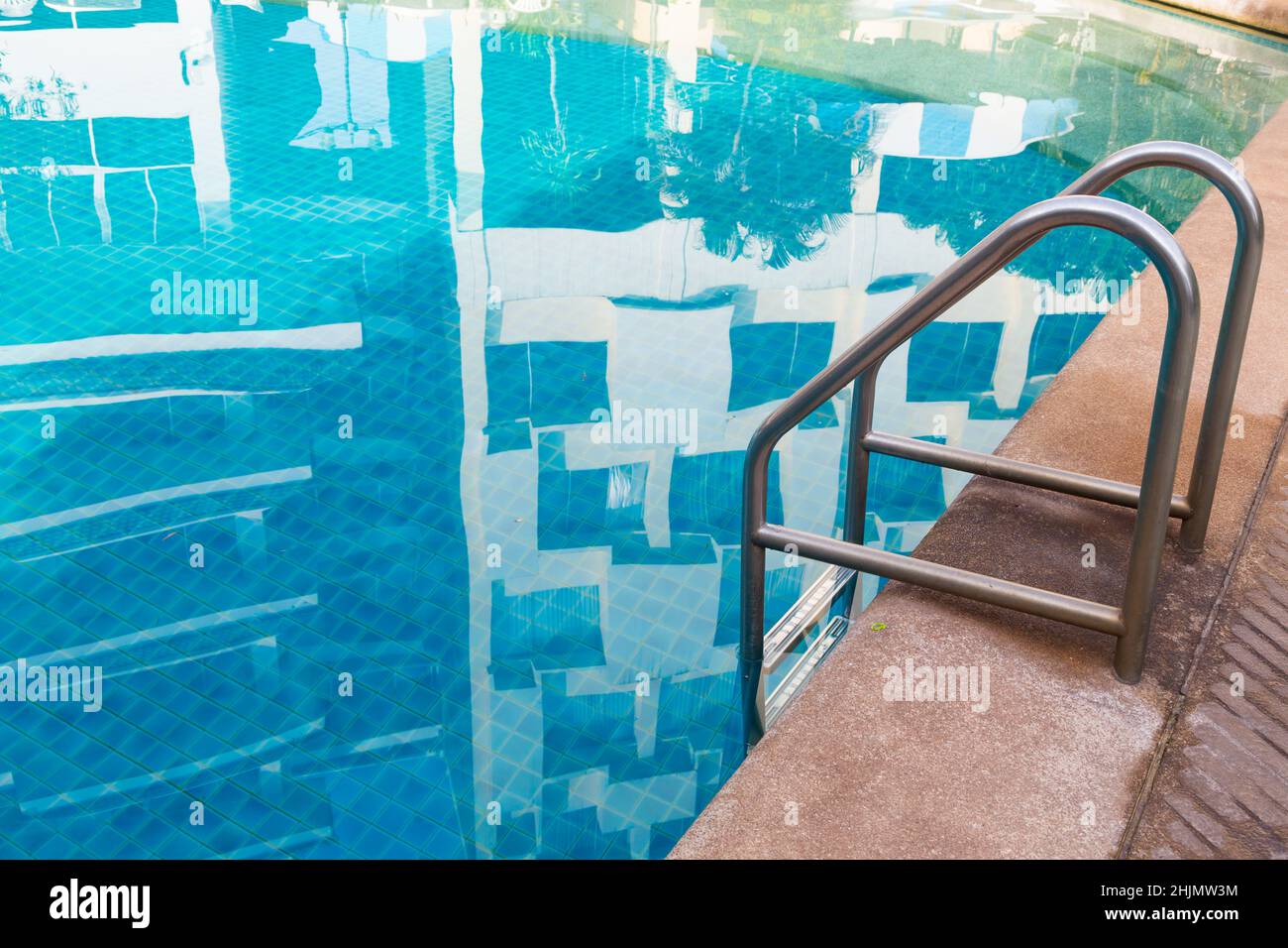 Grab bars ladder in the blue swimming pool background Stock Photo - Alamy