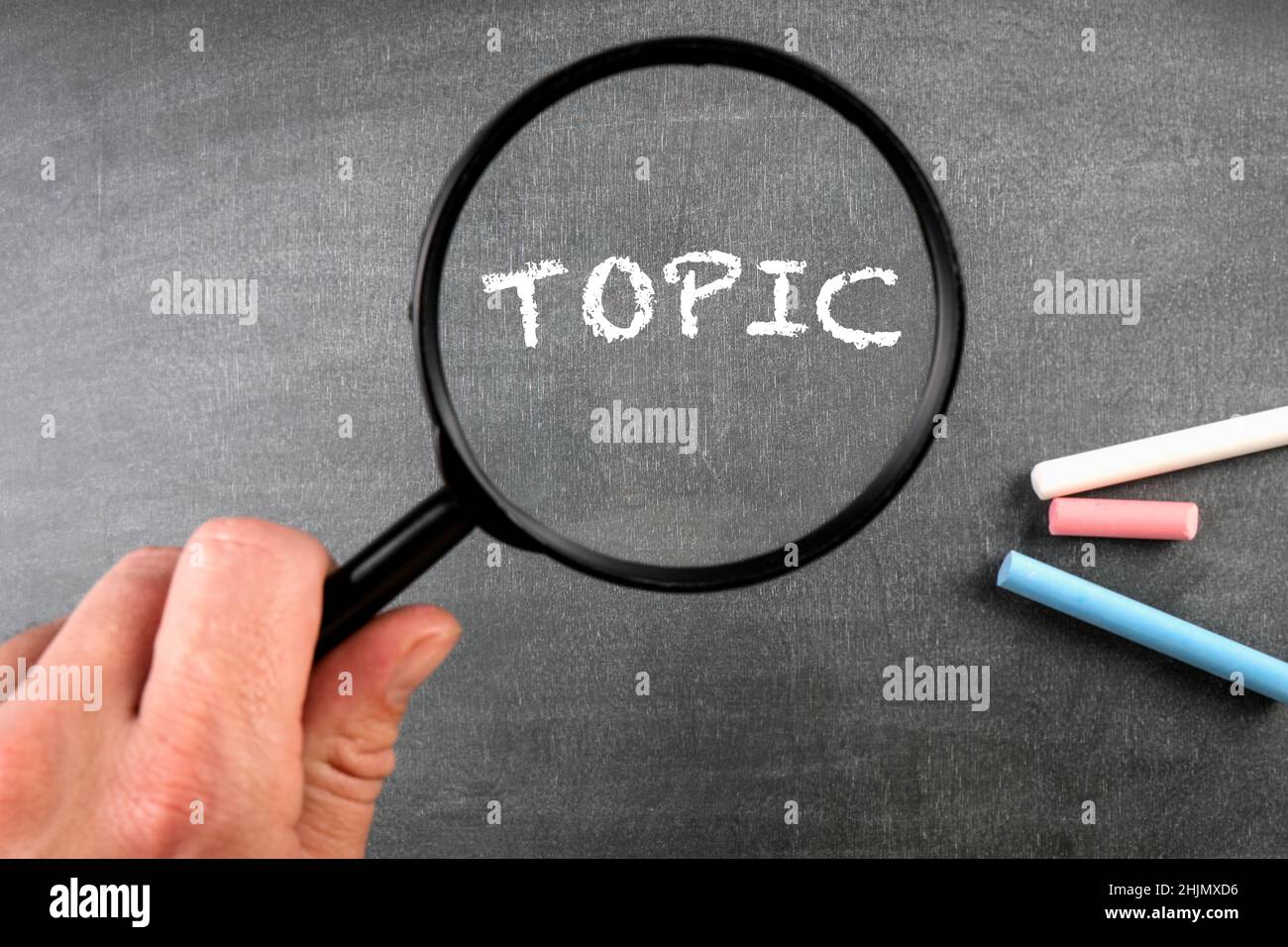 TOPIC. Text and magnifying glass on a black chalkboard Stock Photo - Alamy