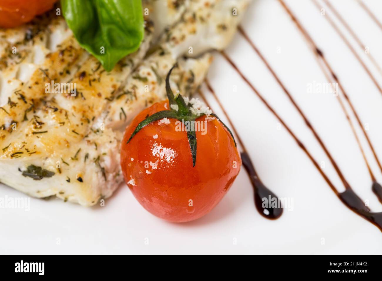 Baked fish fillet with tomatoes and basil. Macro. Can be used as a ...