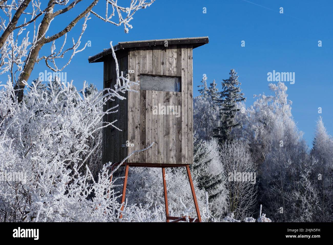 Wooden lookout tower for hunting in winter landscape with frozen trees ...