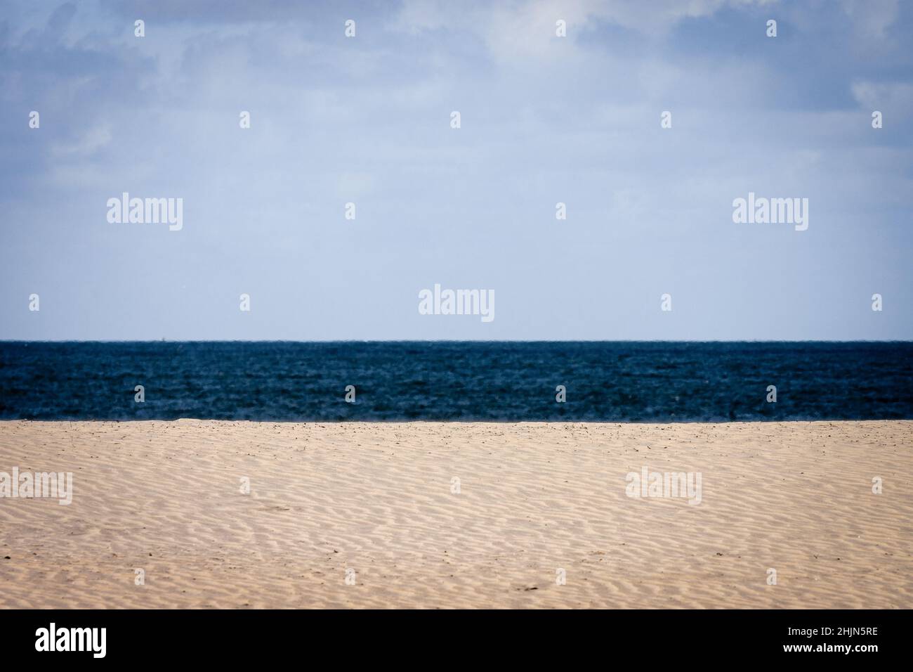 Beautiful view of a sandy beach and blue dune water sky under a light ...