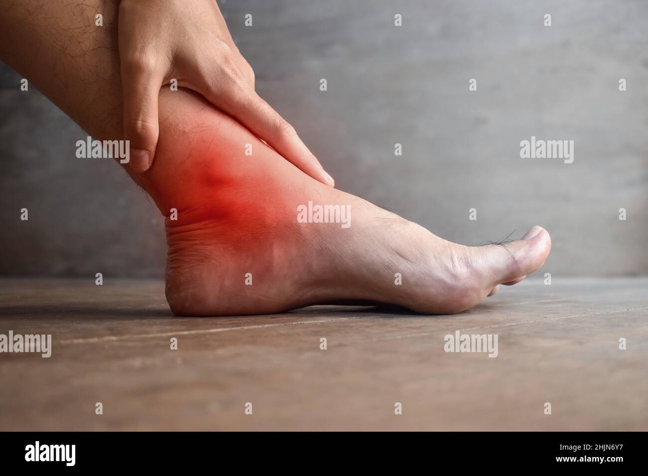 Inflammation of Asian young man’s ankle joint and foot. Concept of ...
