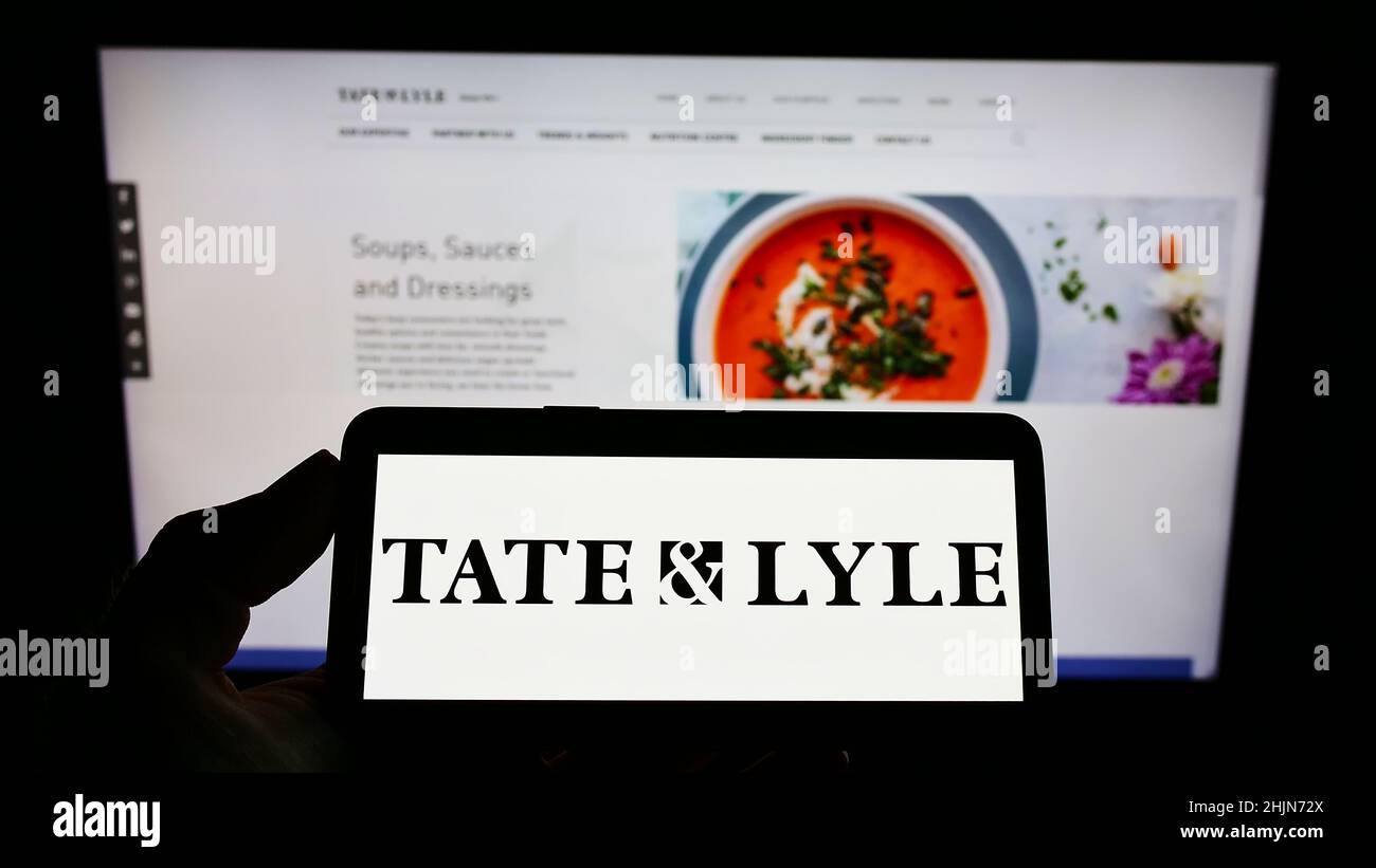 Person holding mobile phone with logo of British food processing ...