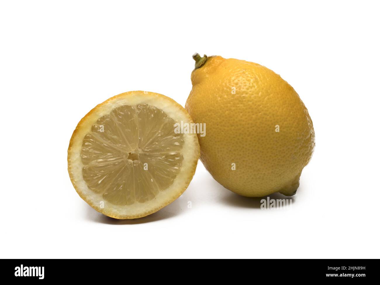 Close up of whole and cut half lemon showing the inside on white ...