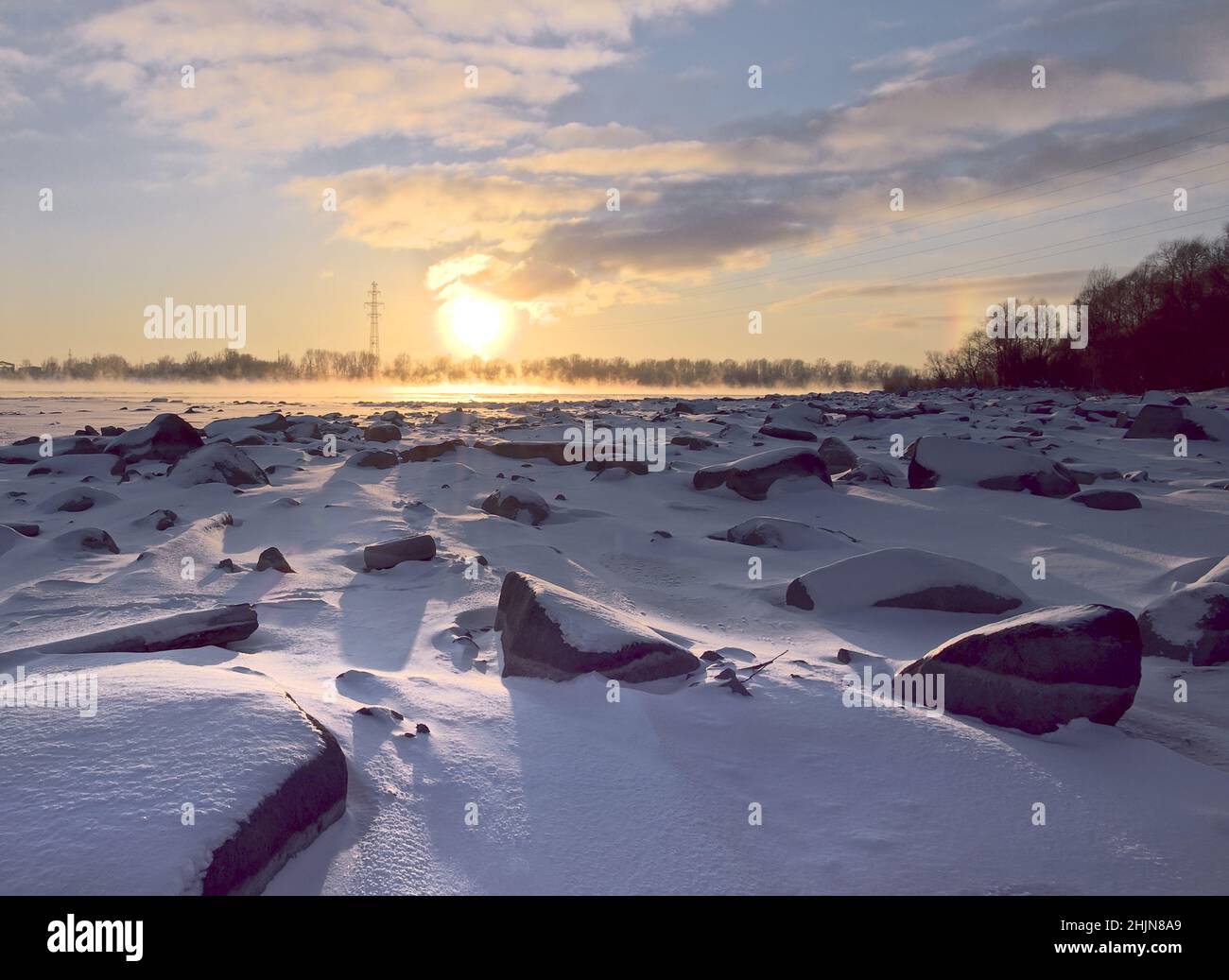 Sun ball at sunset. The stone banks of the Ob are covered with snow ...