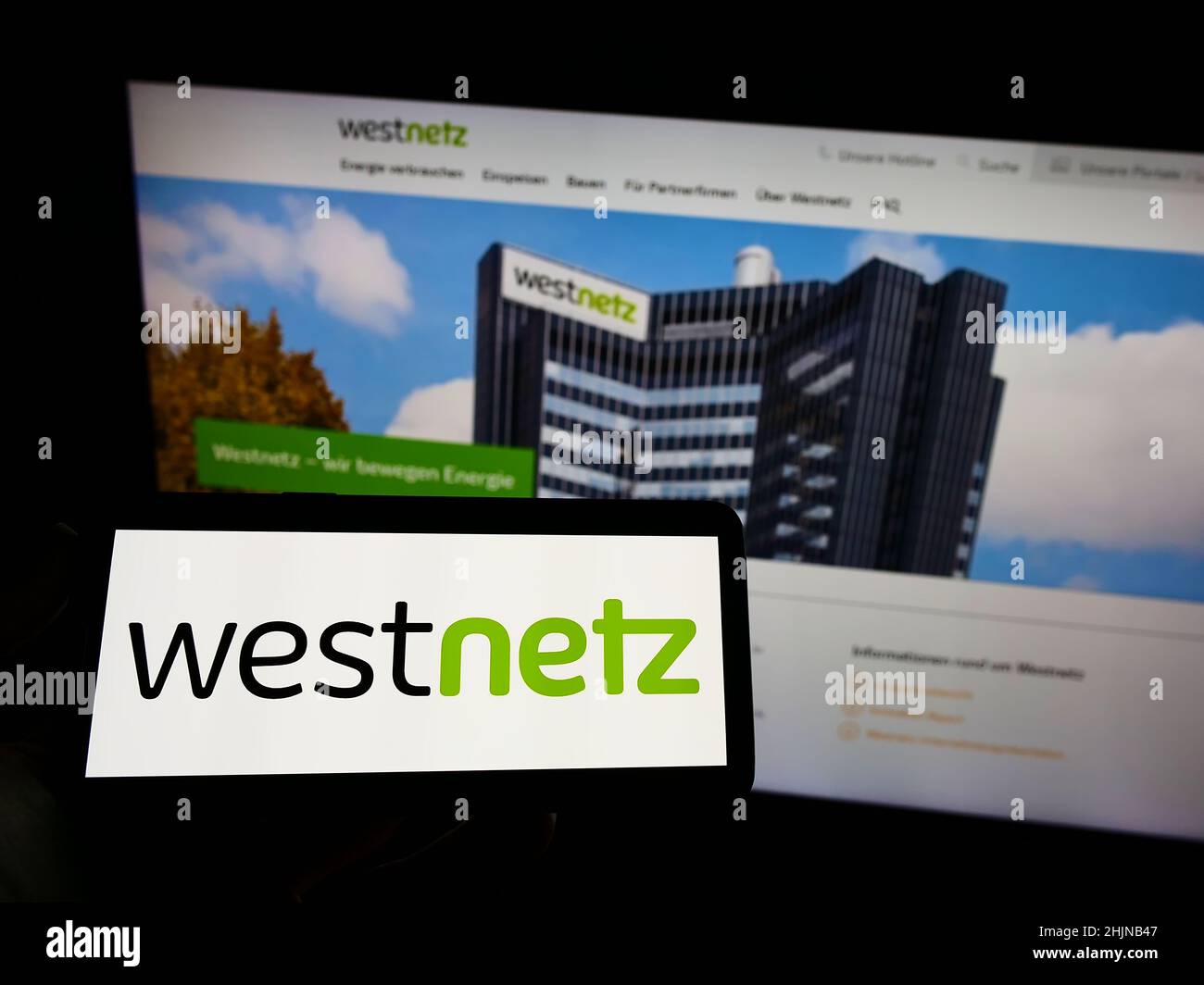 Person holding cellphone with logo of German company Westnetz GmbH on ...