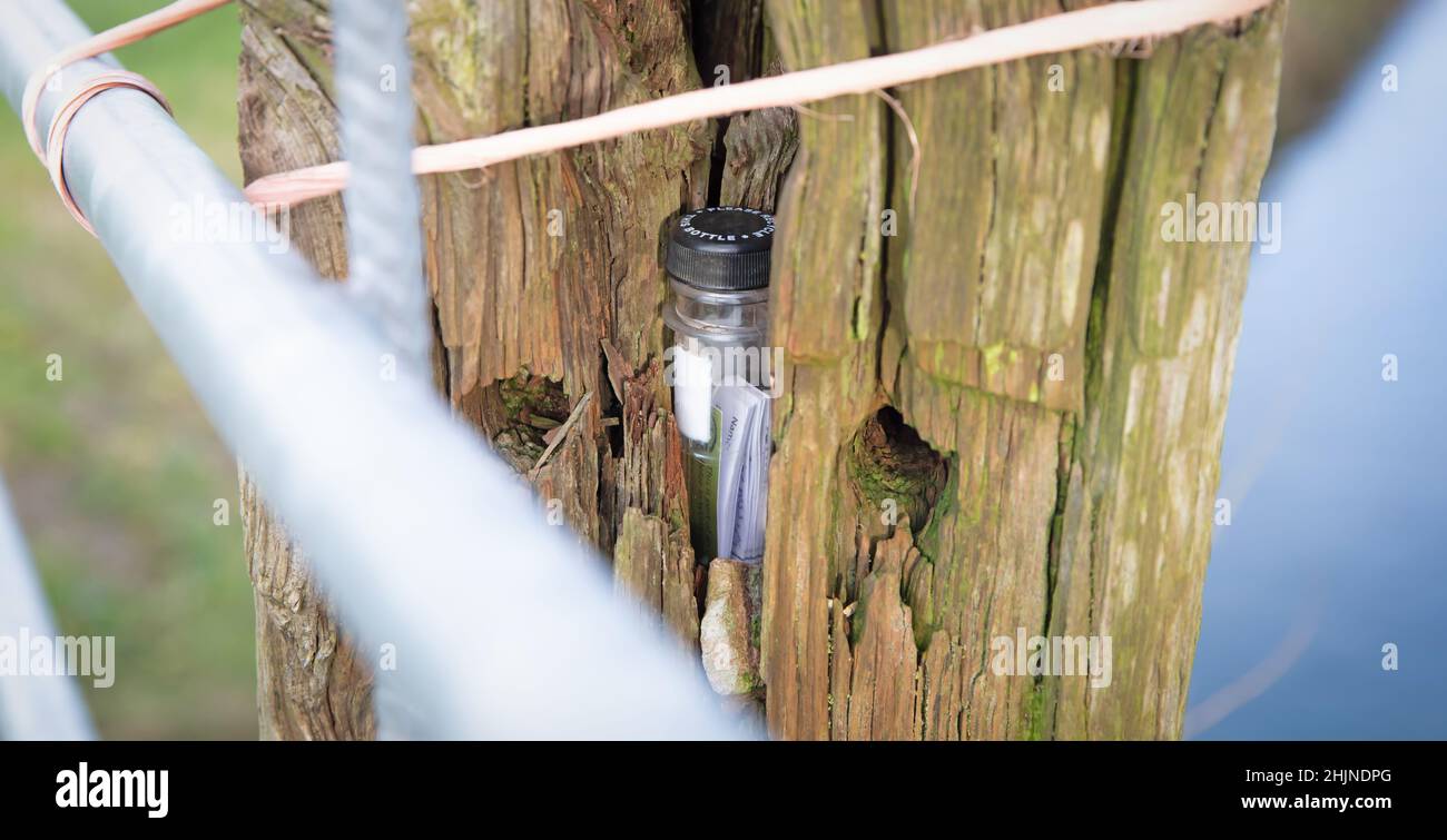 Geocache hidden at a fence in the dutch landscape, selective focus ...