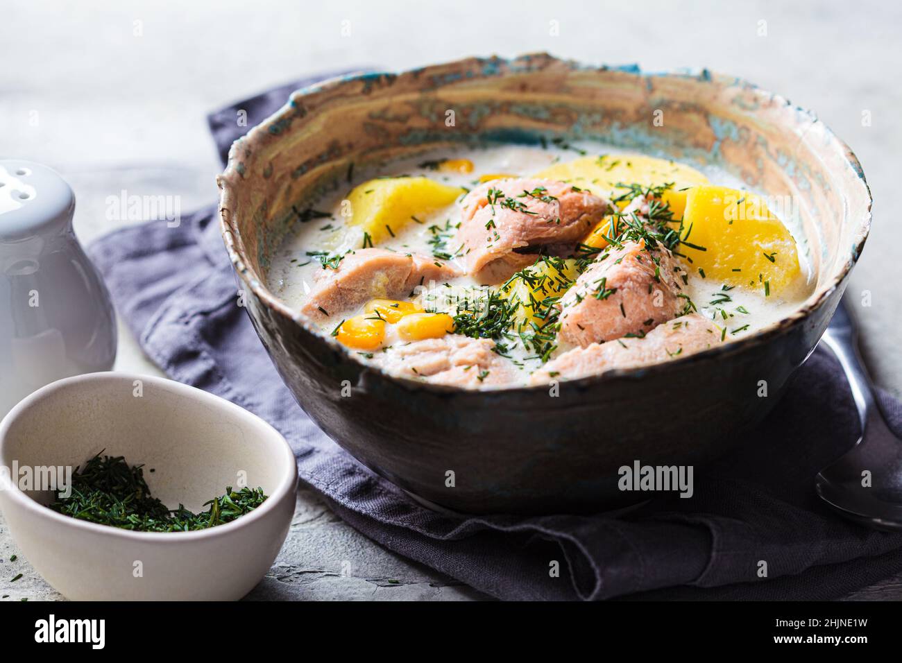 Norwegian fish soup with trout, potatoes and corn, gray background ...
