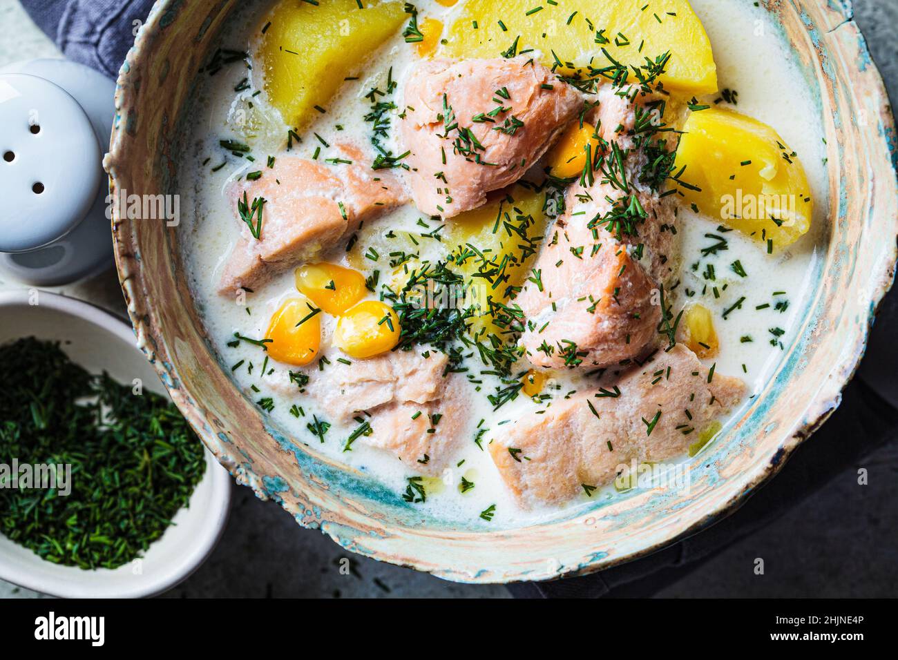 Norwegian fish soup with trout, potatoes and corn, gray background, top ...