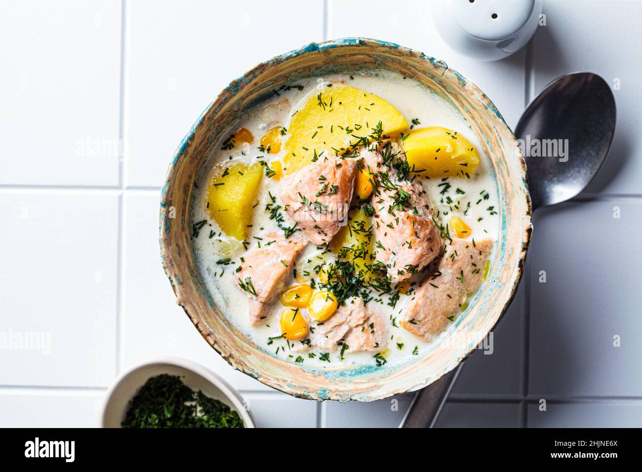 Norwegian fish soup with trout, potatoes and corn, white tile ...