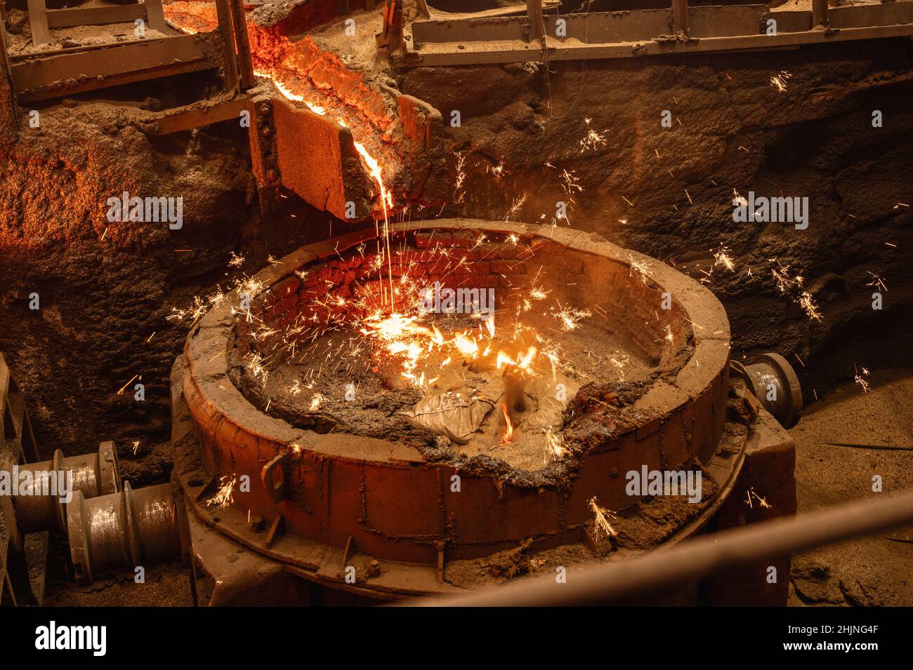 Molten iron. Liquid metal is poured into the ladle in a thin stream ...