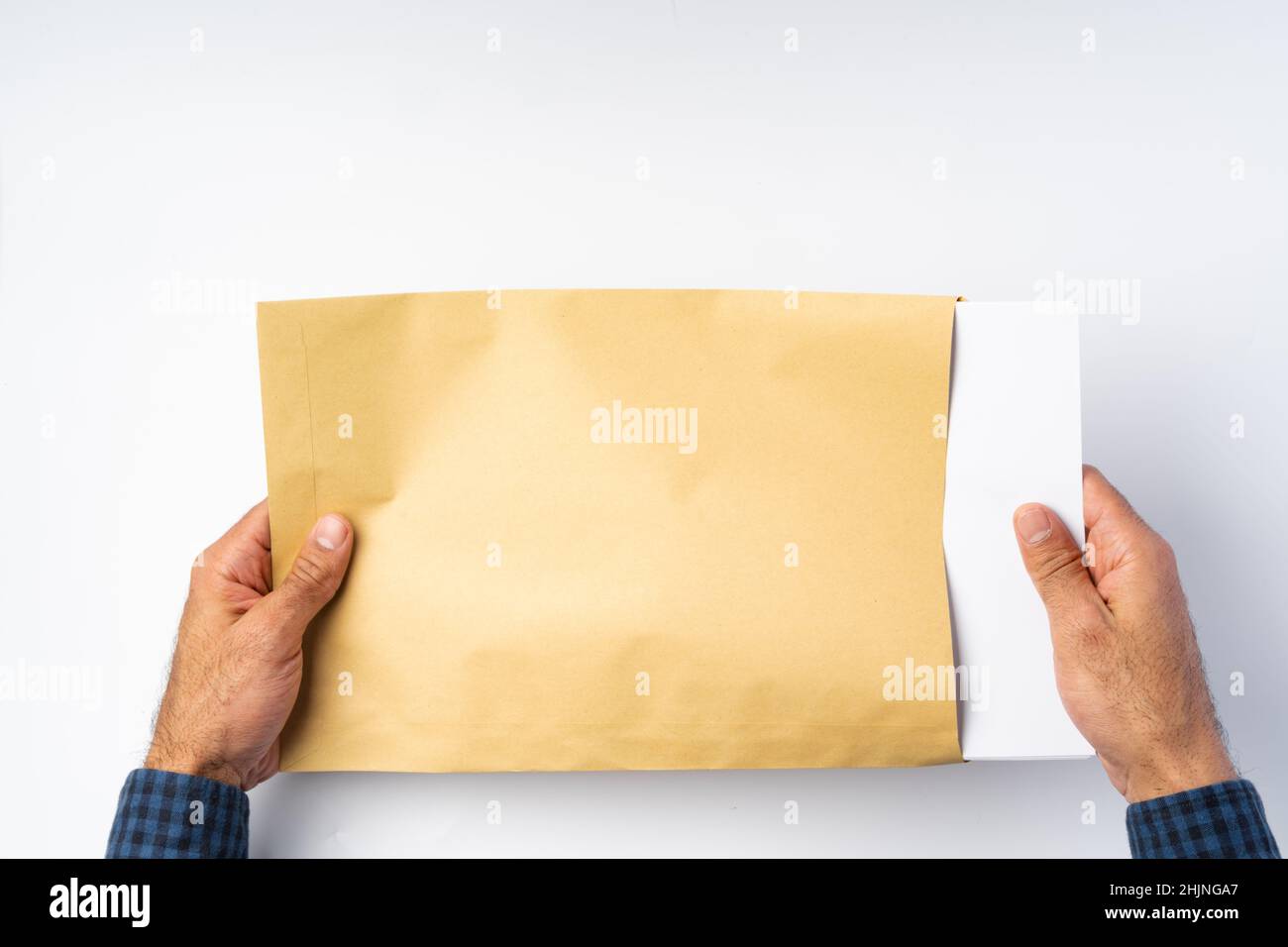 Top view of male hands hold (open) an envelope above white background ...