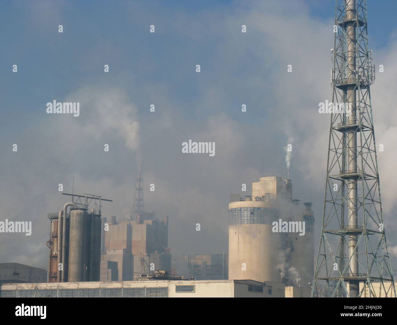 Factory buildings release smokes during daytime Stock Photo - Alamy