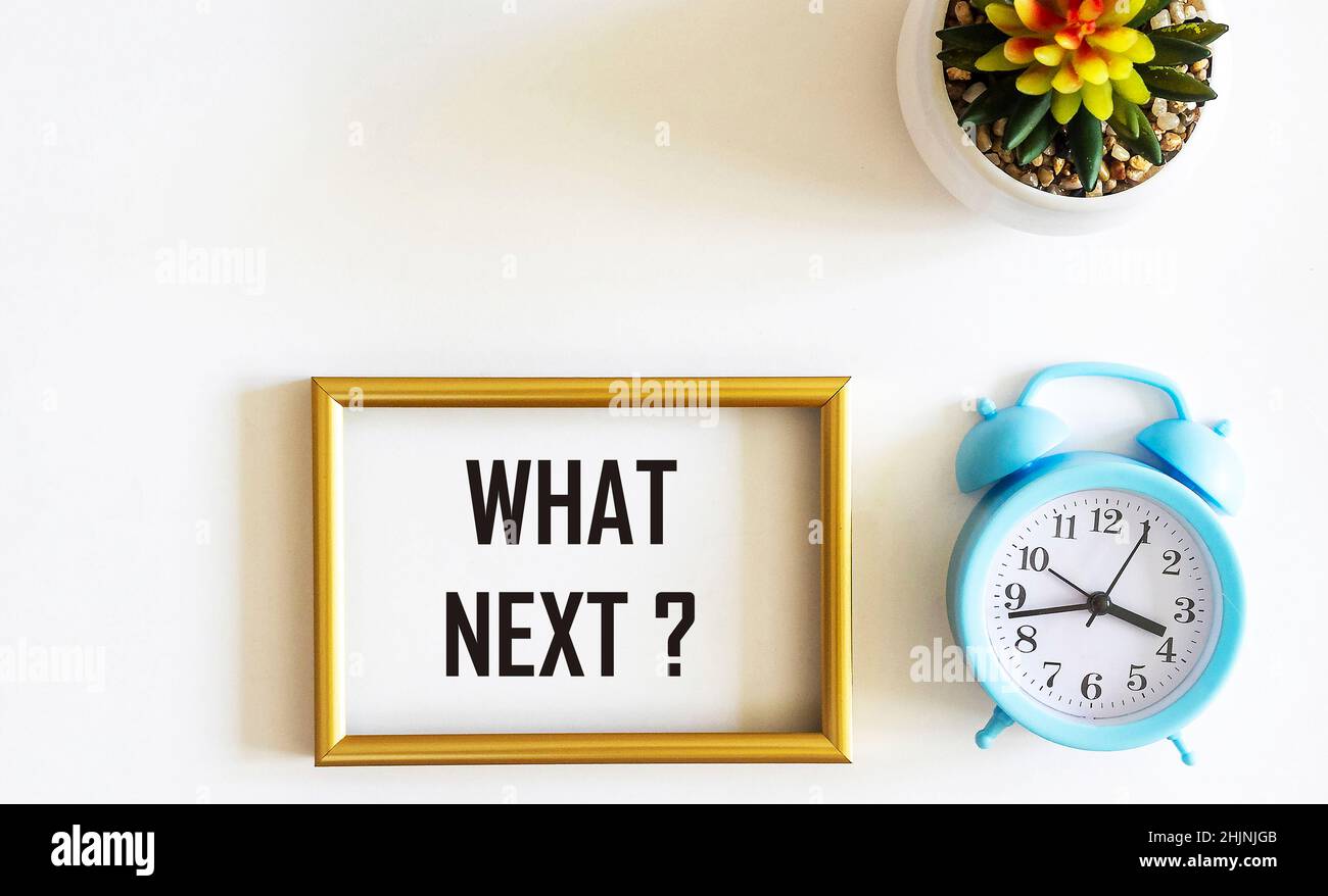 Text WHAT NEXT in golden frame on white background with clock and ...