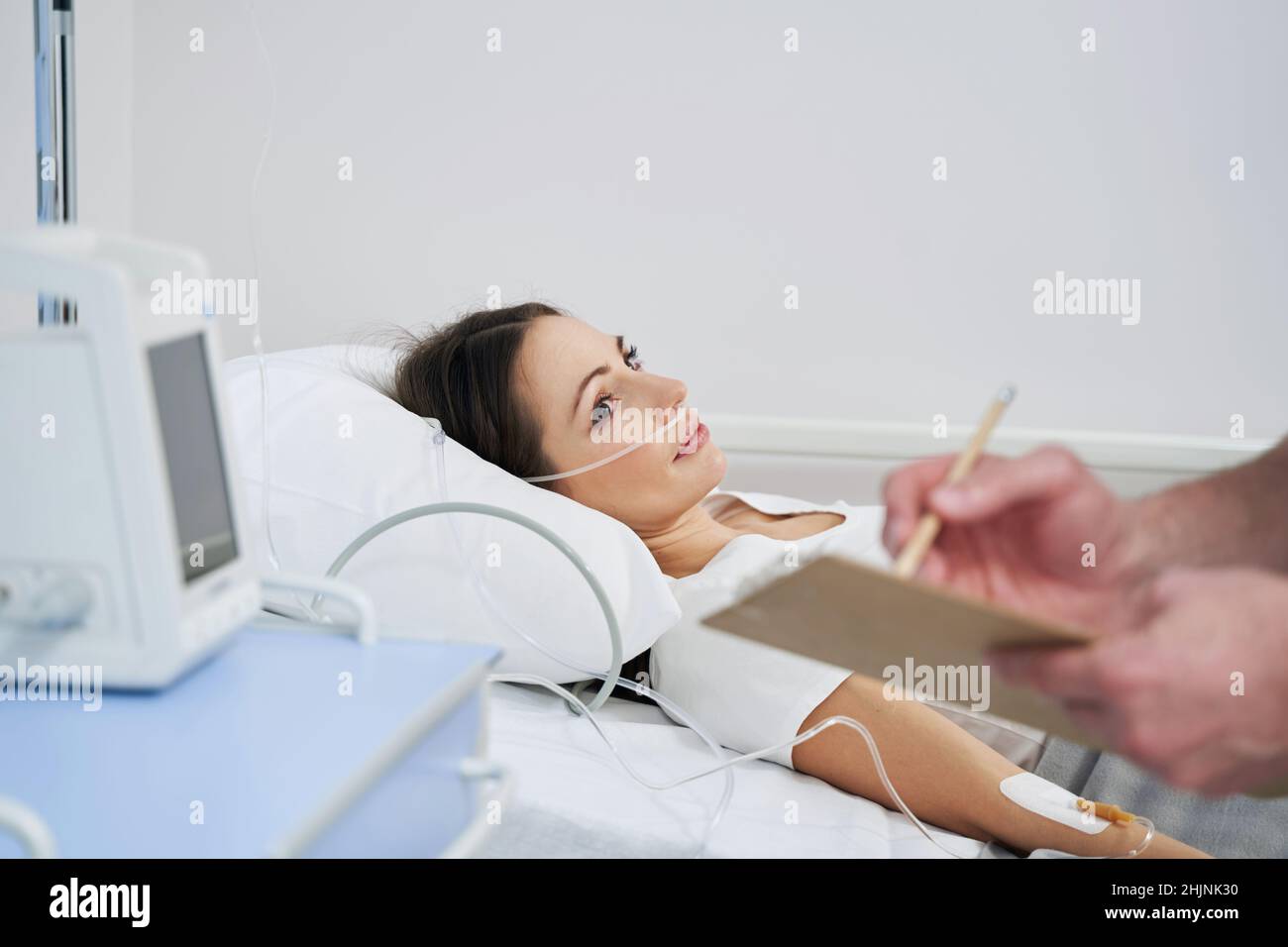 Female patient looking at attending doctor during treatment procedure ...