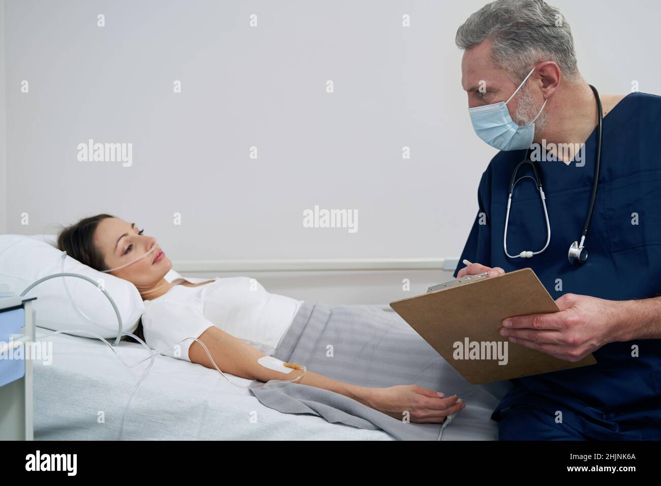 Doctor assessing young woman health condition during ward round Stock ...