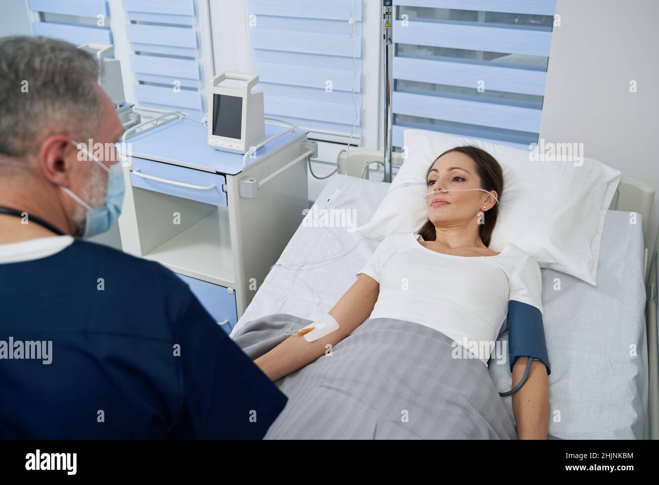 Attending doctor monitoring female patient on intravenous therapy Stock ...