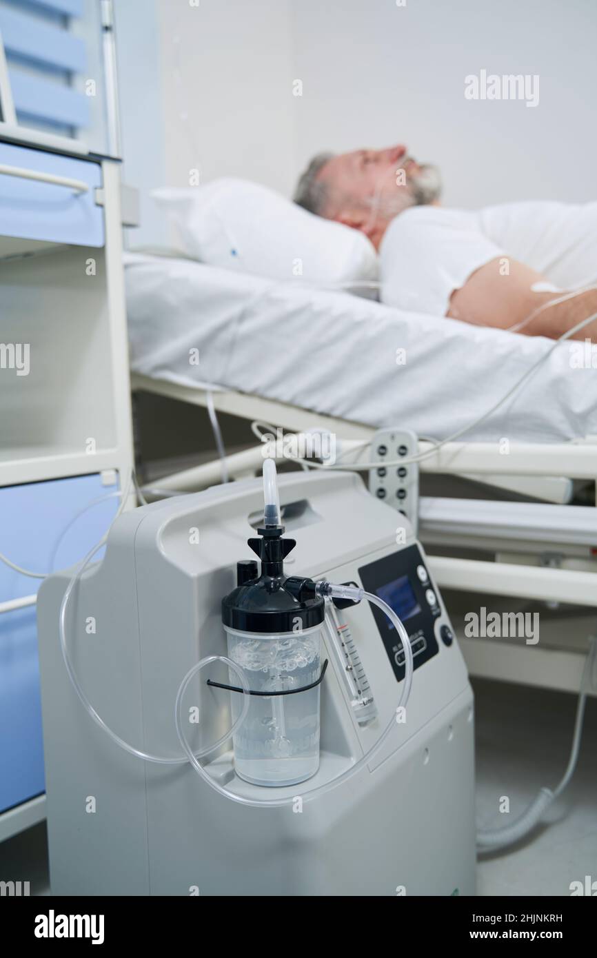 Recumbent male patient connected to portable oxygen concentrator Stock ...