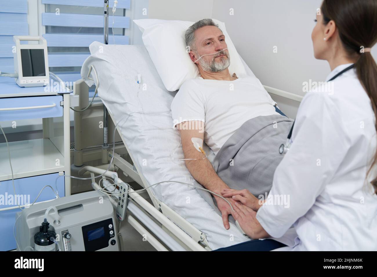 Physician attending to a woman in bed hi-res stock photography and ...