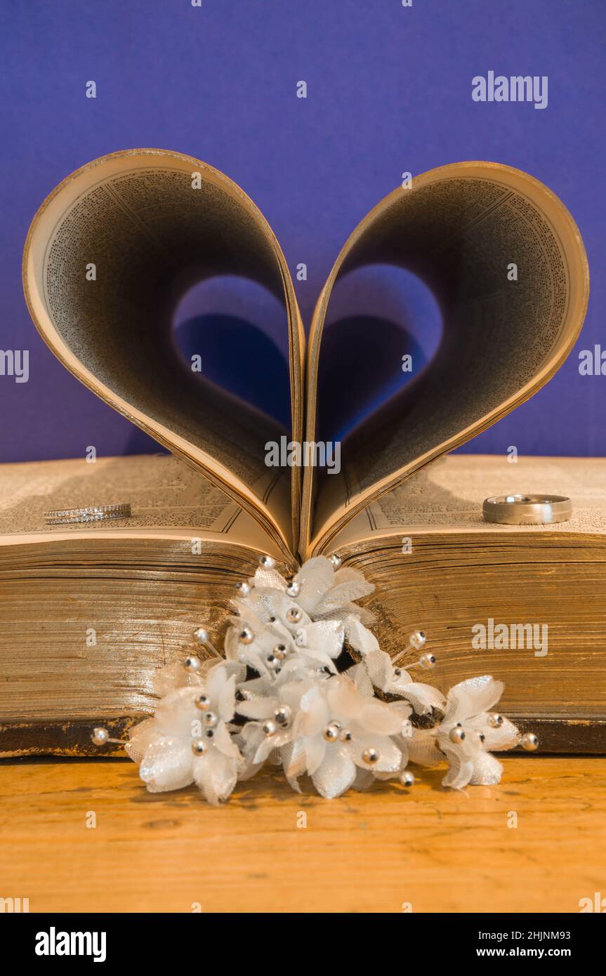 Heart shaped pages of bible with wedding rings Stock Photo - Alamy