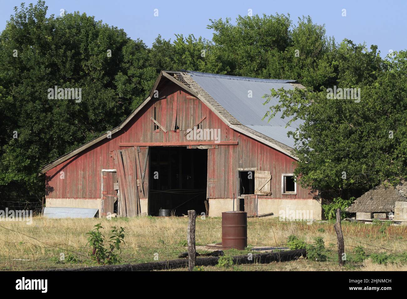 Kansas country Red Barn with tree's and blue sky out in the country ...