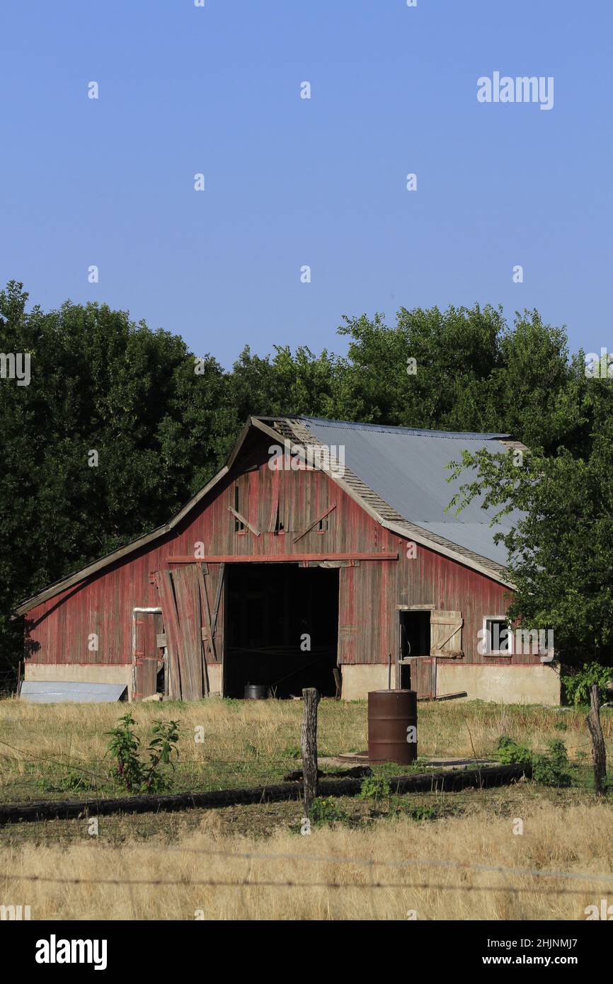 Kansas country Red Barn with tree's and blue sky out in the country ...