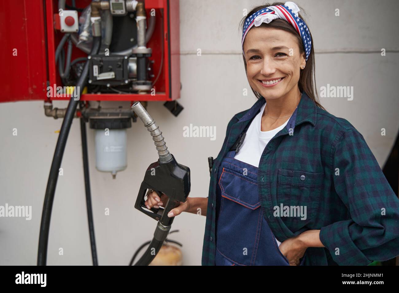 Smiling pretty Caucasian female with red fuel pump isolated on white ...