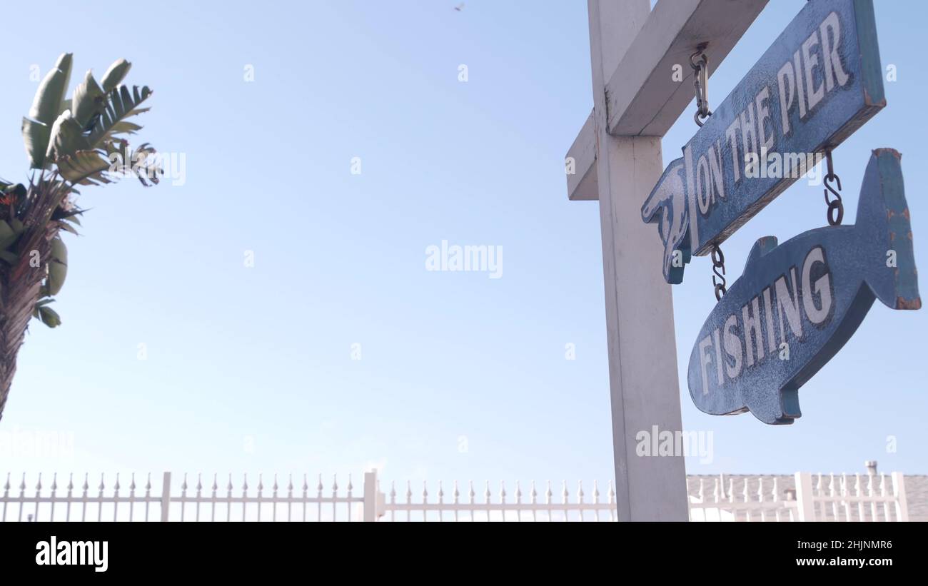 Fishing on pier wooden blue sign, California ocean beach, USA. Coast ...