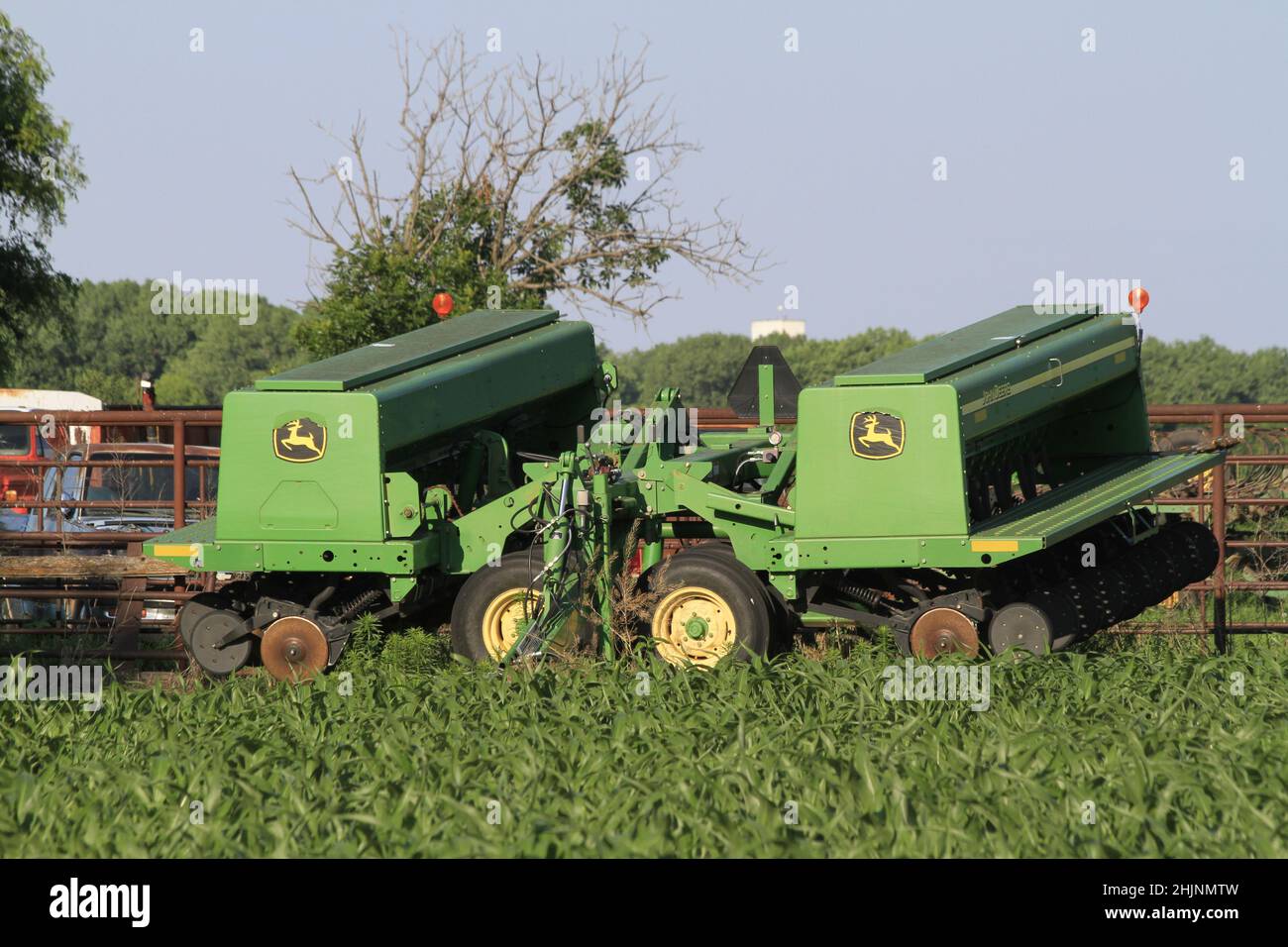 John Deere planting Drills with blue sky and green field Stock Photo ...