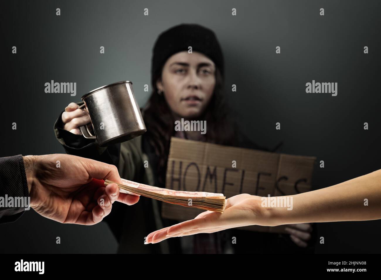 Man gives a stack of cash to woman, hands close up. Defocused begging ...