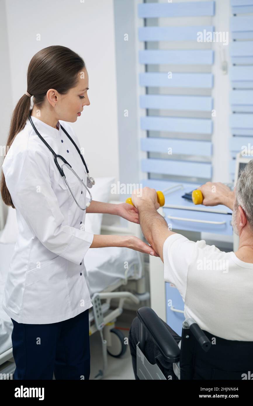 Disabled person working out with experienced kinesiologist Stock Photo ...
