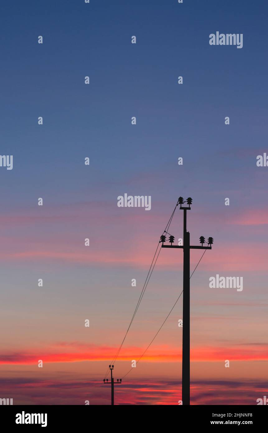 Silhouette of power lines against the background of a bright sunset ...