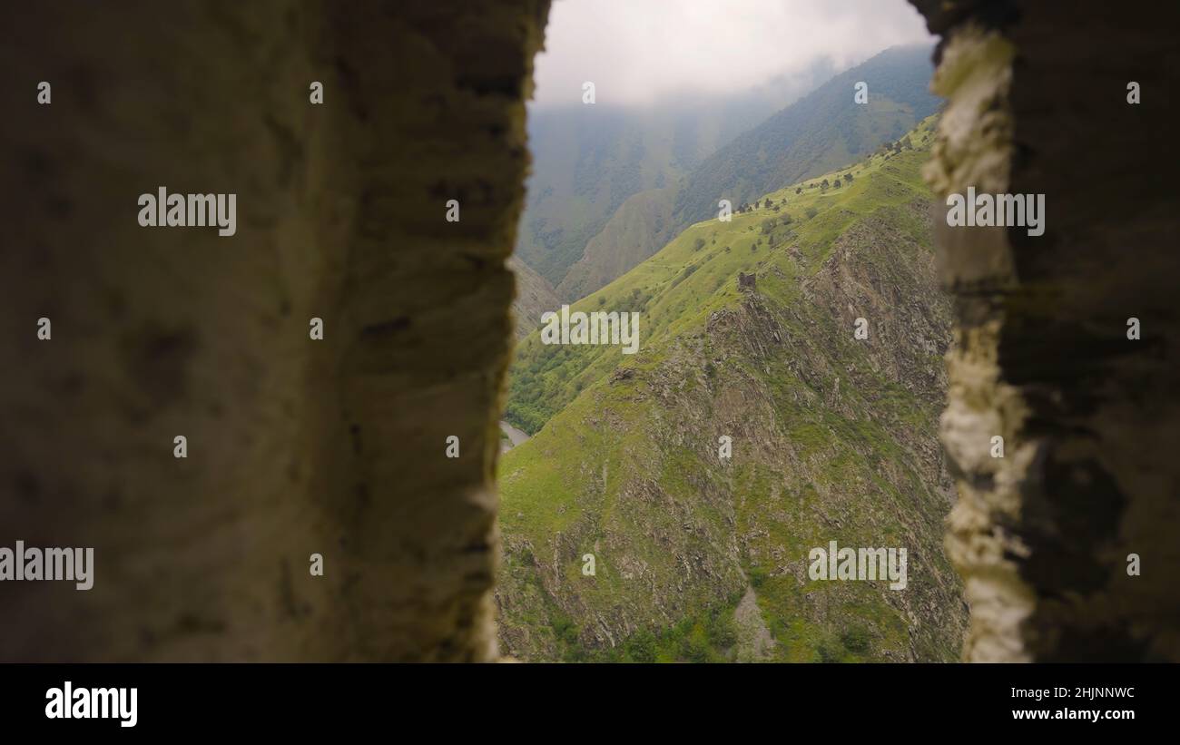 Beautiful view of mountains from window of ruins. Action. Stone arch ...