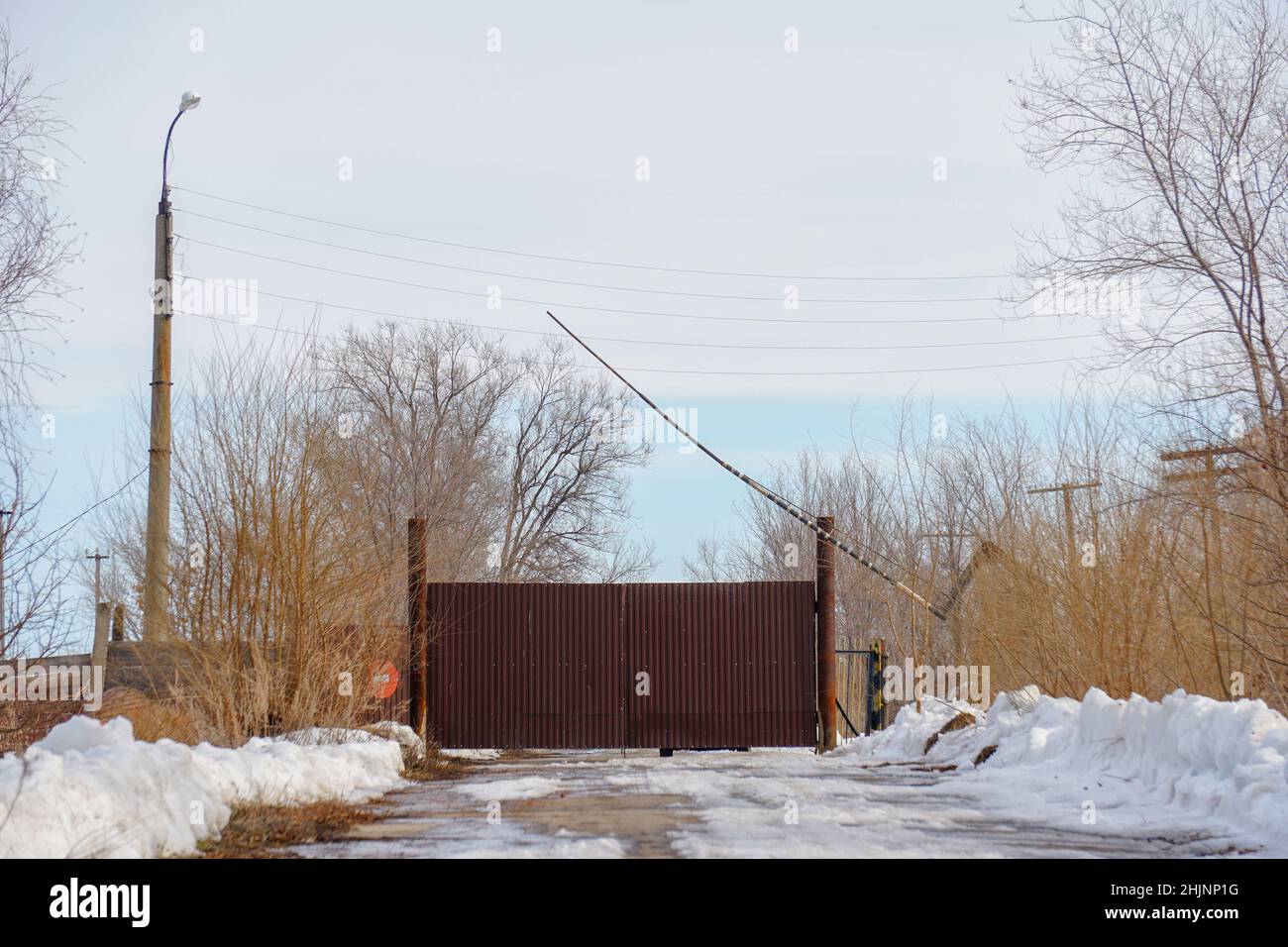 Iron gates and a barrier on an old abandoned road. Restricted area ...