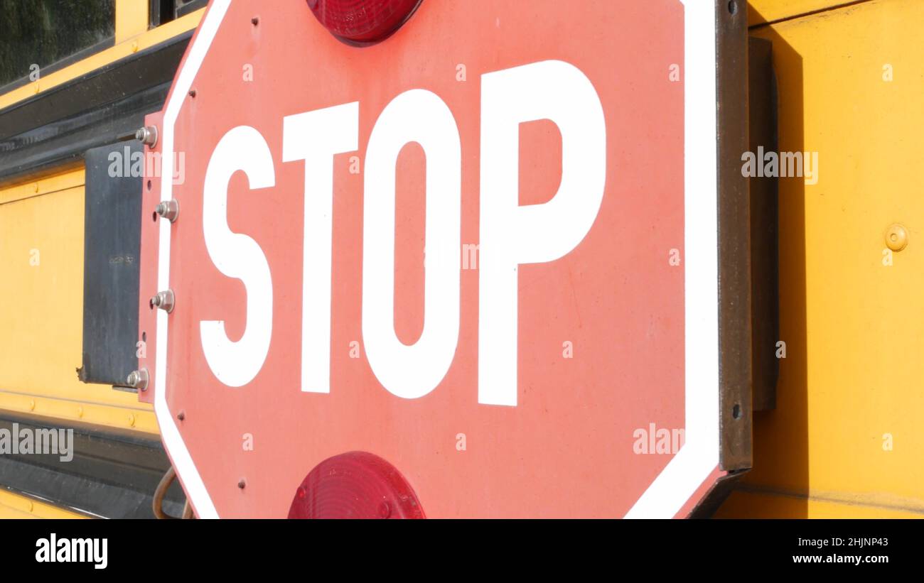 Red stop sign, yellow school bus in California, USA. Traffic warning on ...
