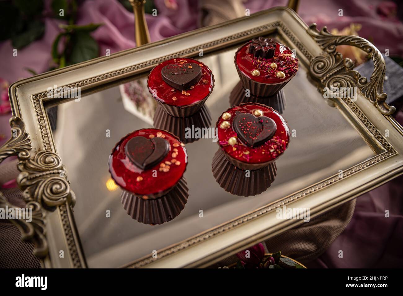 Fancy chocolate praline in cupcake shapes with cherry cream filling ...