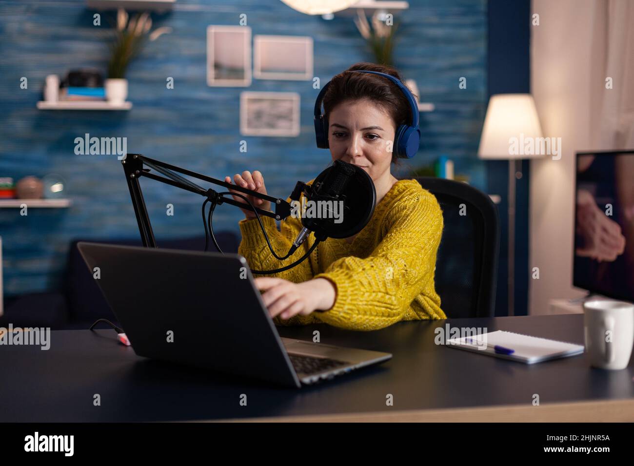 Portrait of social media influencer wearing studio headphones talking ...