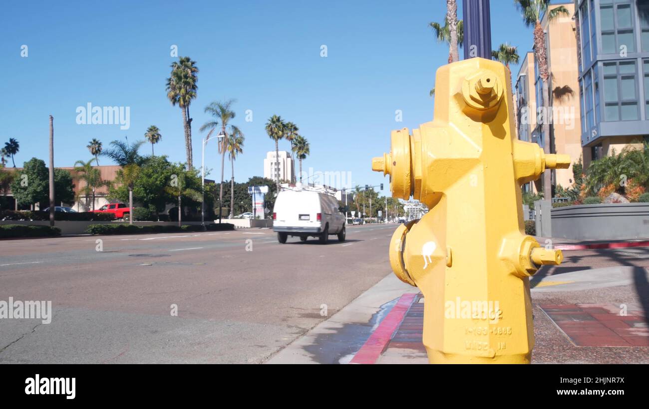 Yellow fire hydrant extinguisher on pavement of San Diego city street ...