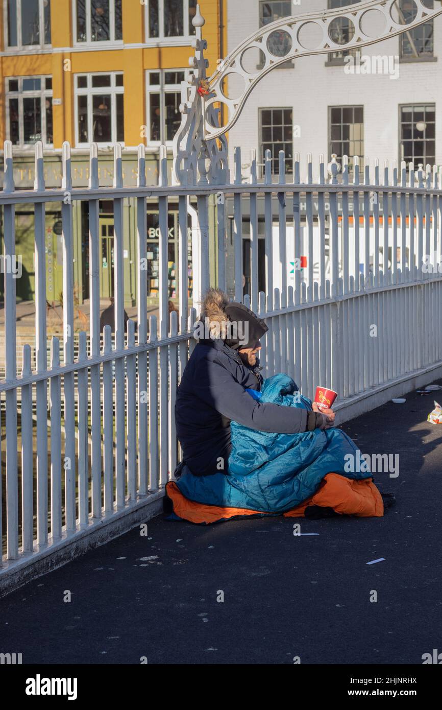 A beggar on the bridge, a homeless young man sitting on the The Penny ...