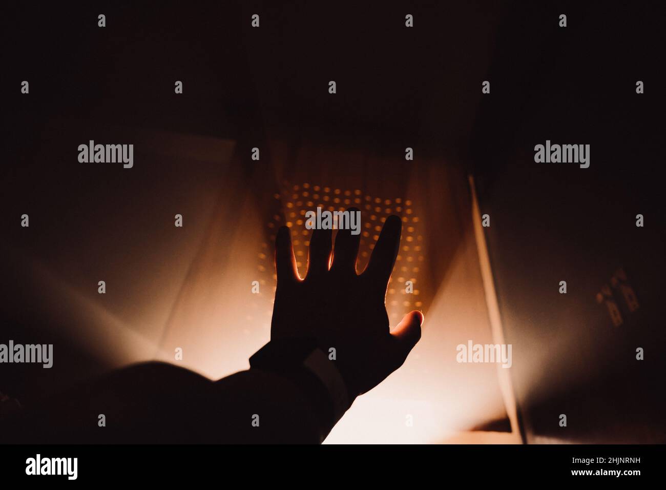 Man's hand in a dark room in sunlight Stock Photo - Alamy