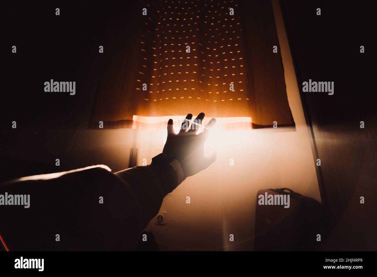 Man's hand in a dark room in sunlight Stock Photo - Alamy